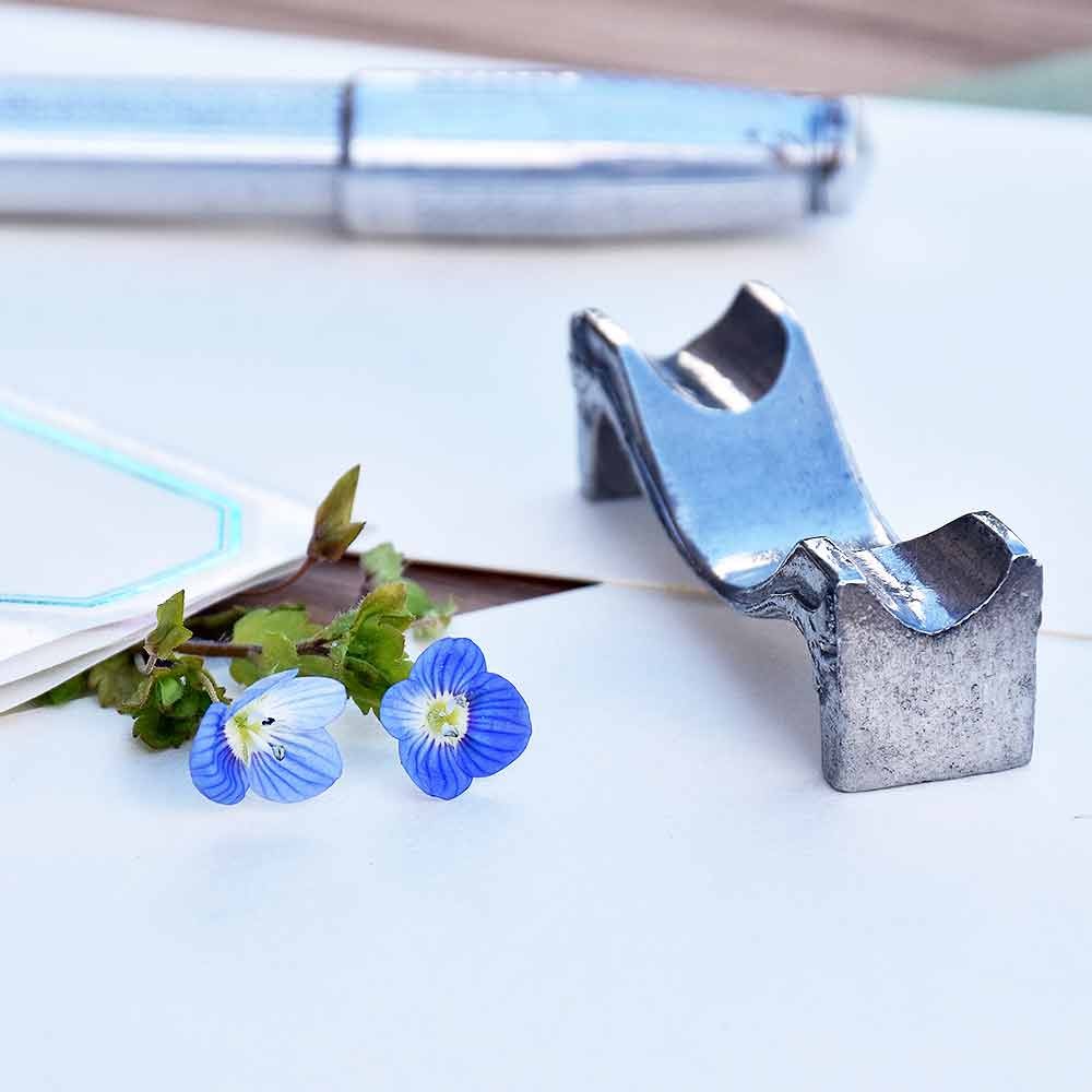 Rectangular pen rest for dip pen, fountain pen, brush or pencil.